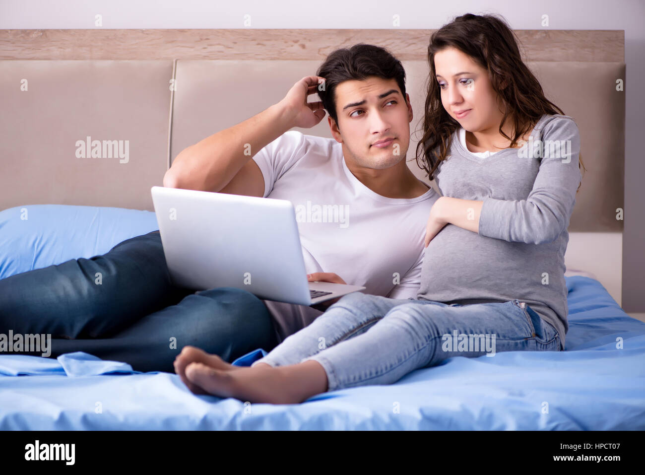 Young family with pregnant wife expecting baby in bed Stock Photo - Alamy