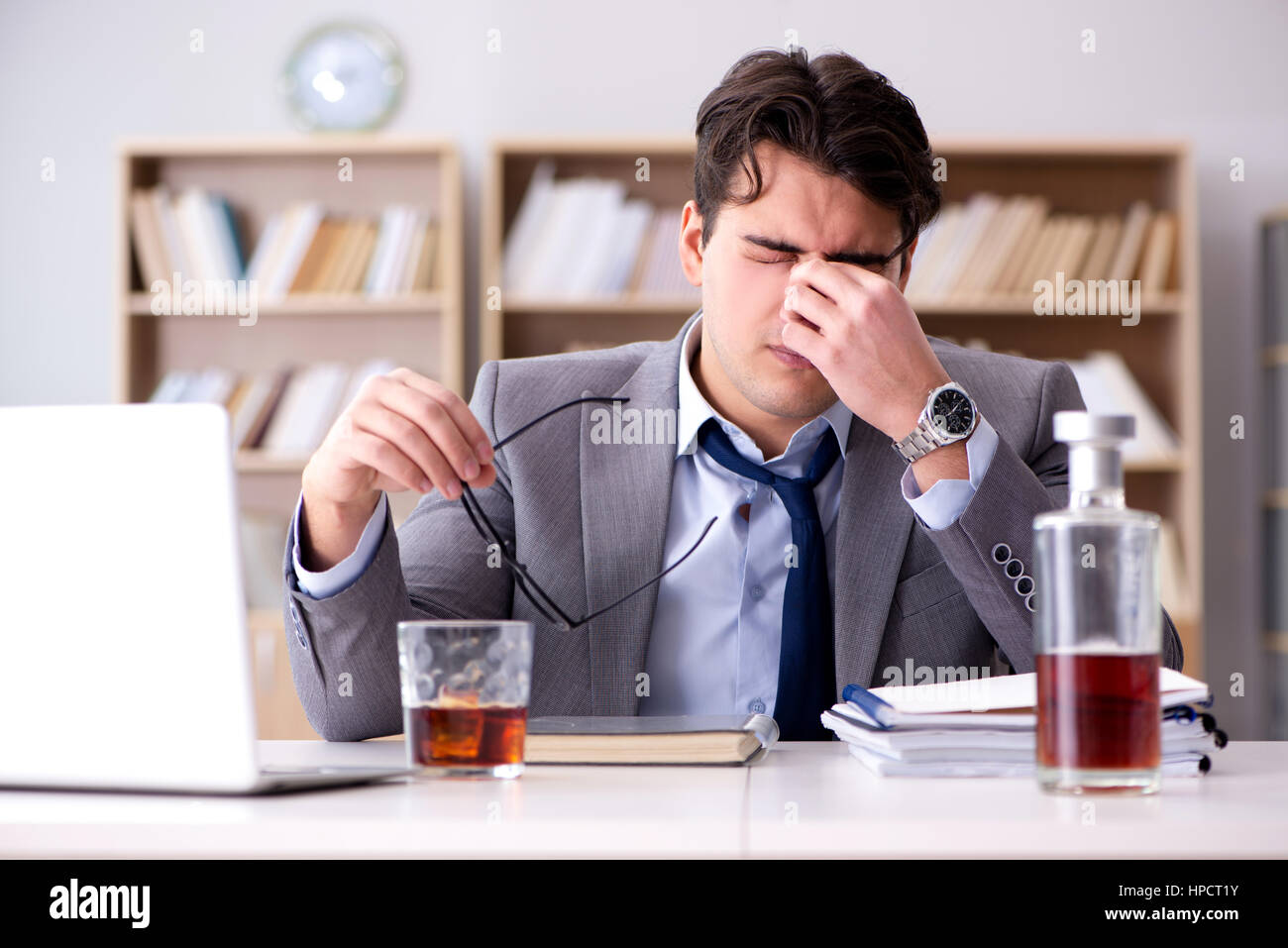 Young businessman drinking from stress Stock Photo - Alamy