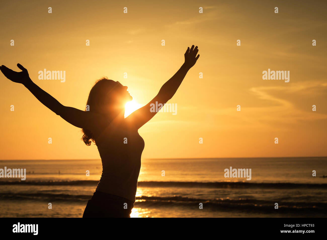 One woman arms open sunset sea hi-res stock photography and images - Alamy