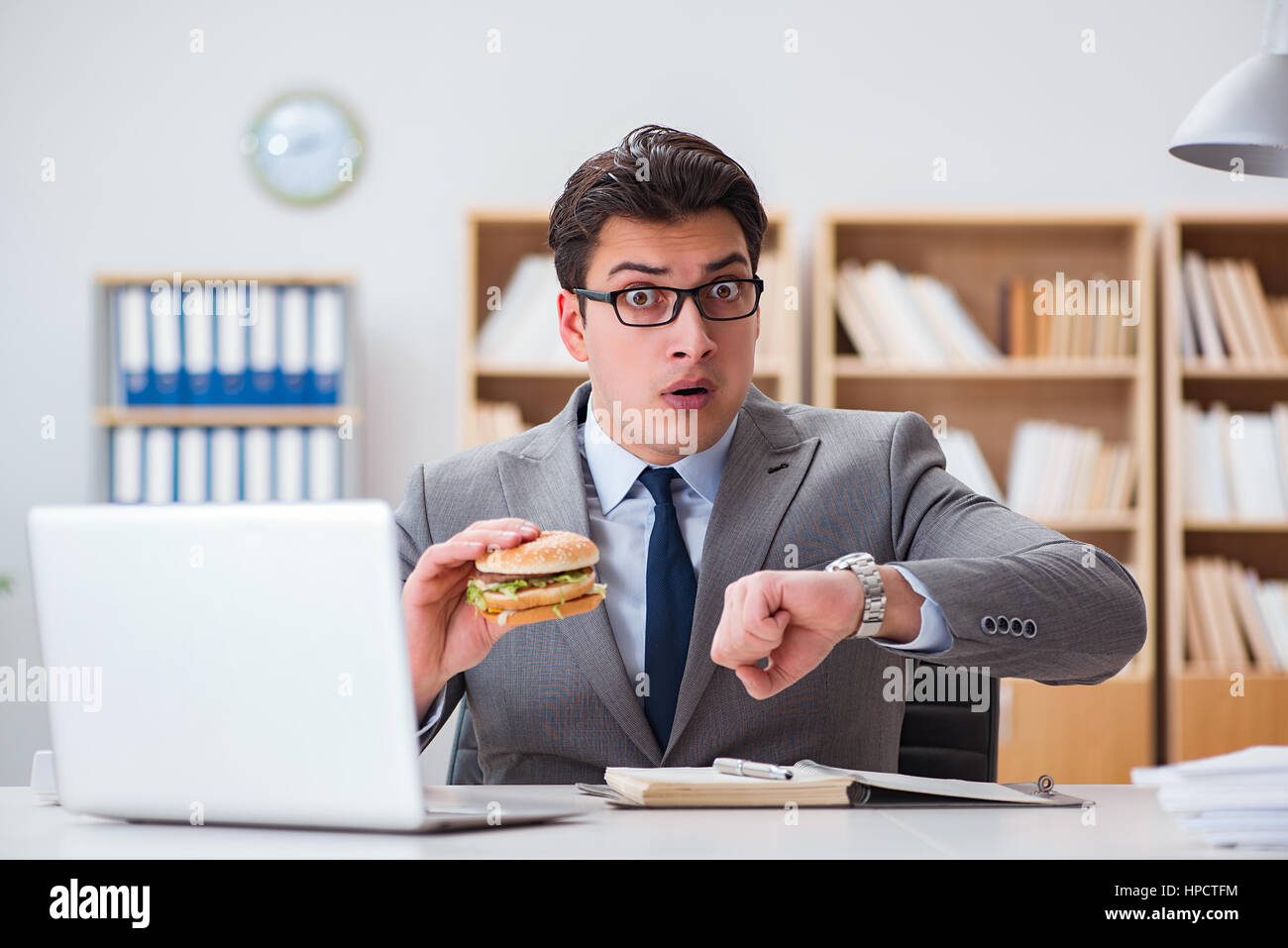Hungry funny businessman eating junk food sandwich Stock Photo - Alamy