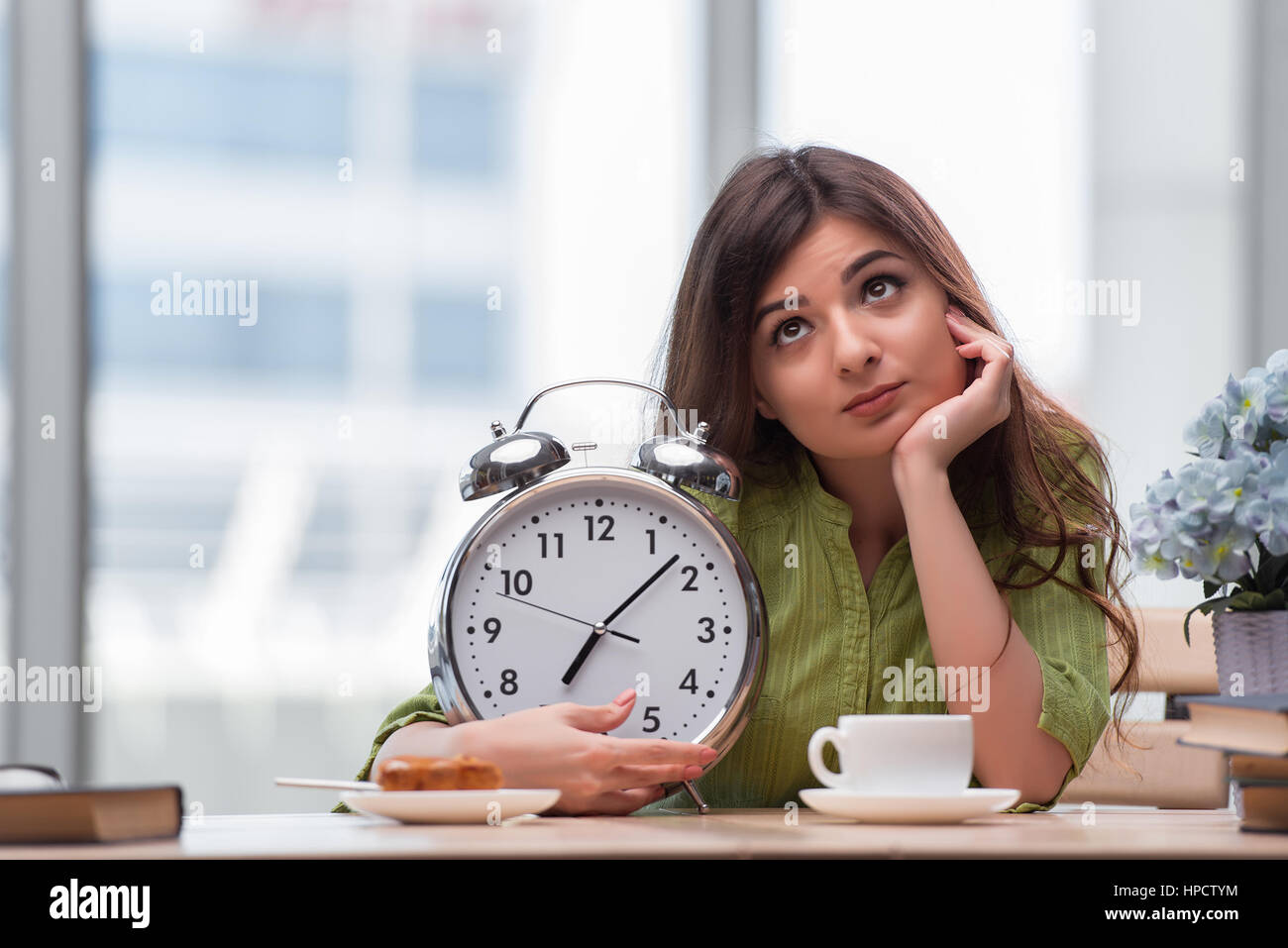 Student with gian alarm clock preparing for exams Stock Photo - Alamy
