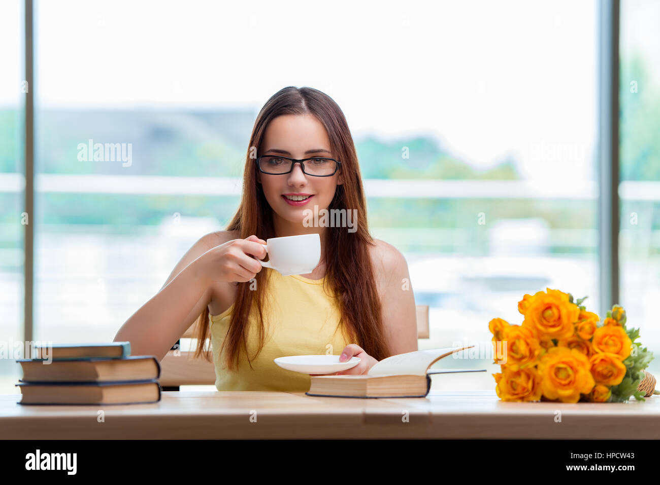 Young student drinking coffee while sudying Stock Photo - Alamy