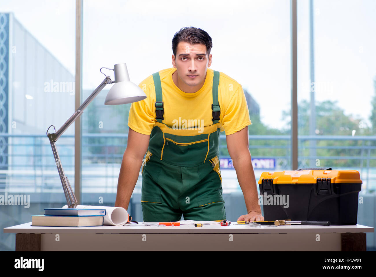 Construction worker sitting at the desk Stock Photo - Alamy