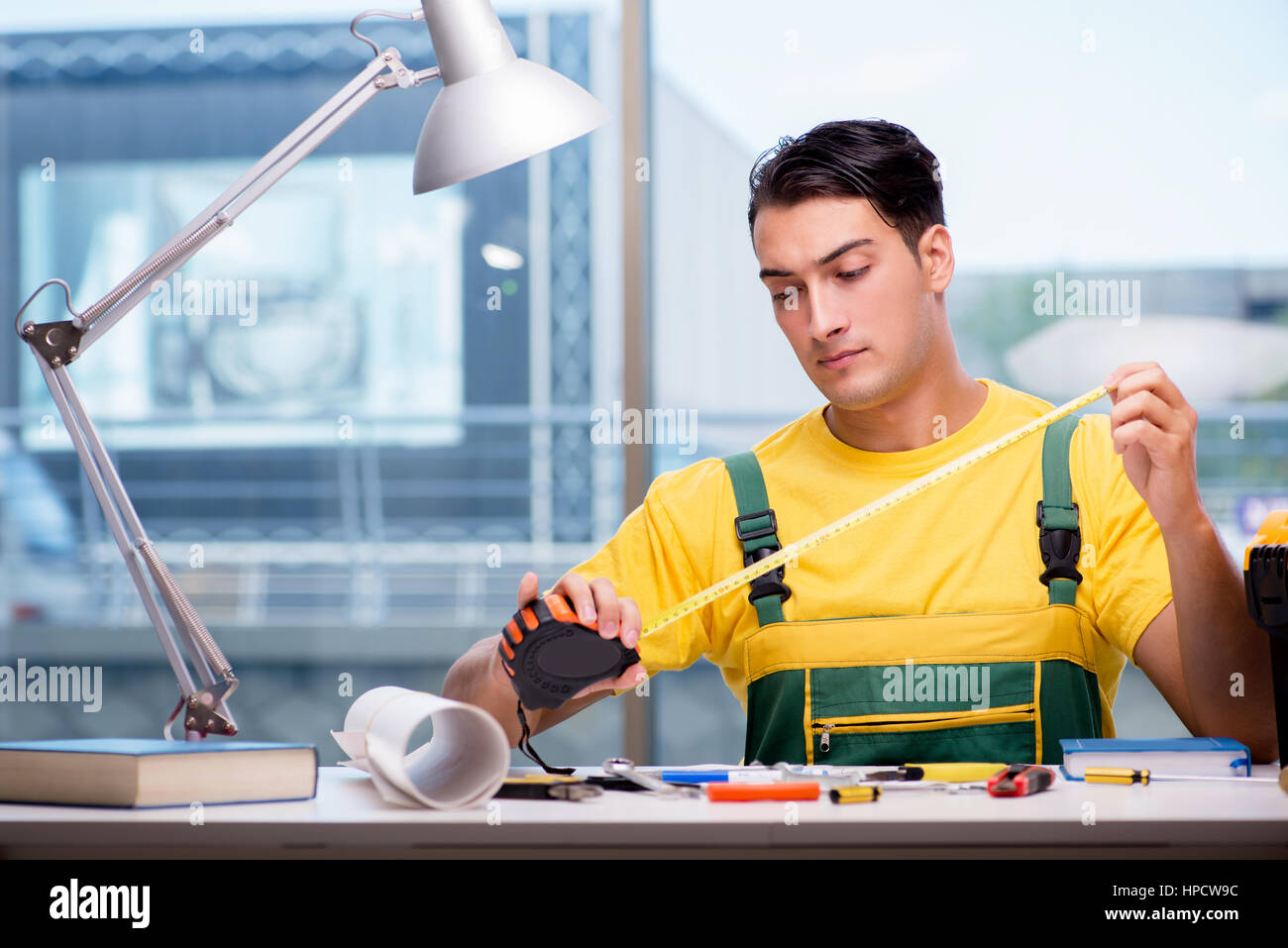 Construction worker sitting at the desk Stock Photo - Alamy