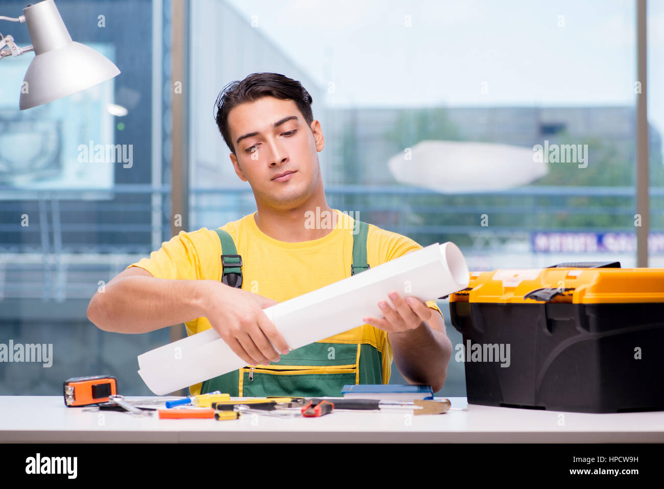 Construction worker sitting at the desk Stock Photo - Alamy