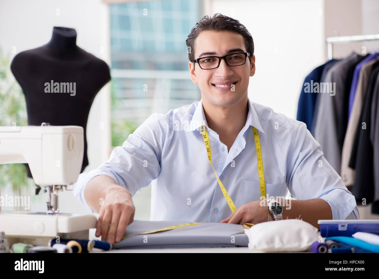Young man tailor working on new clothing Stock Photo - Alamy