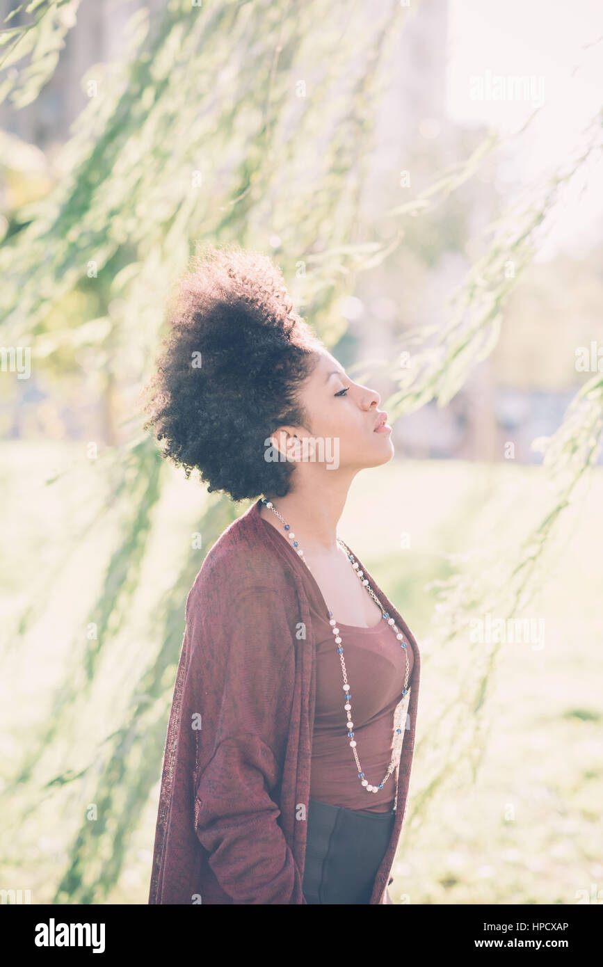 Young beautiful afro black woman outdoor in the city back light feeling ...