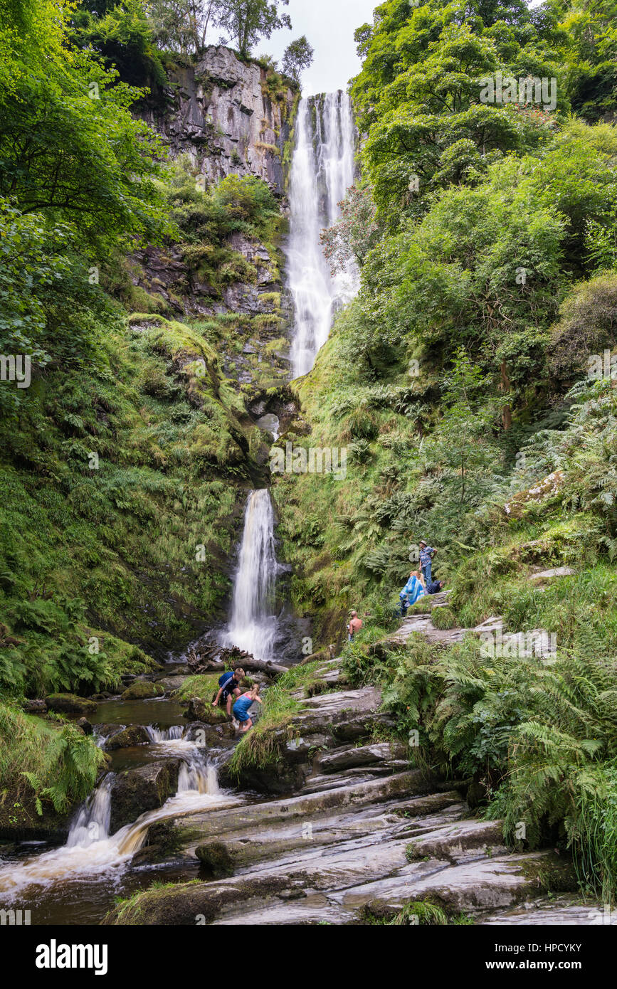 A family explores the rocks below the Pystill Rhaeadr Falls, Wales ...
