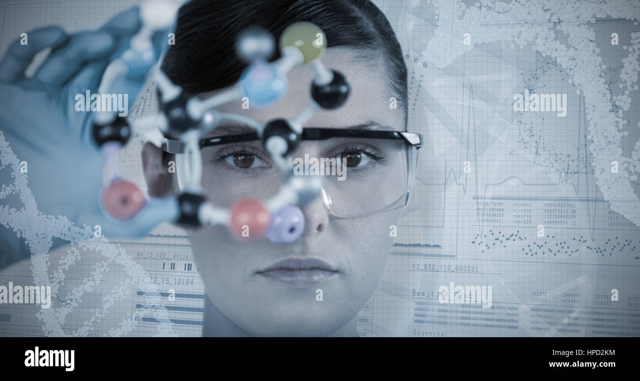 Portrait of female scientist holding molecular model against panoramic ...