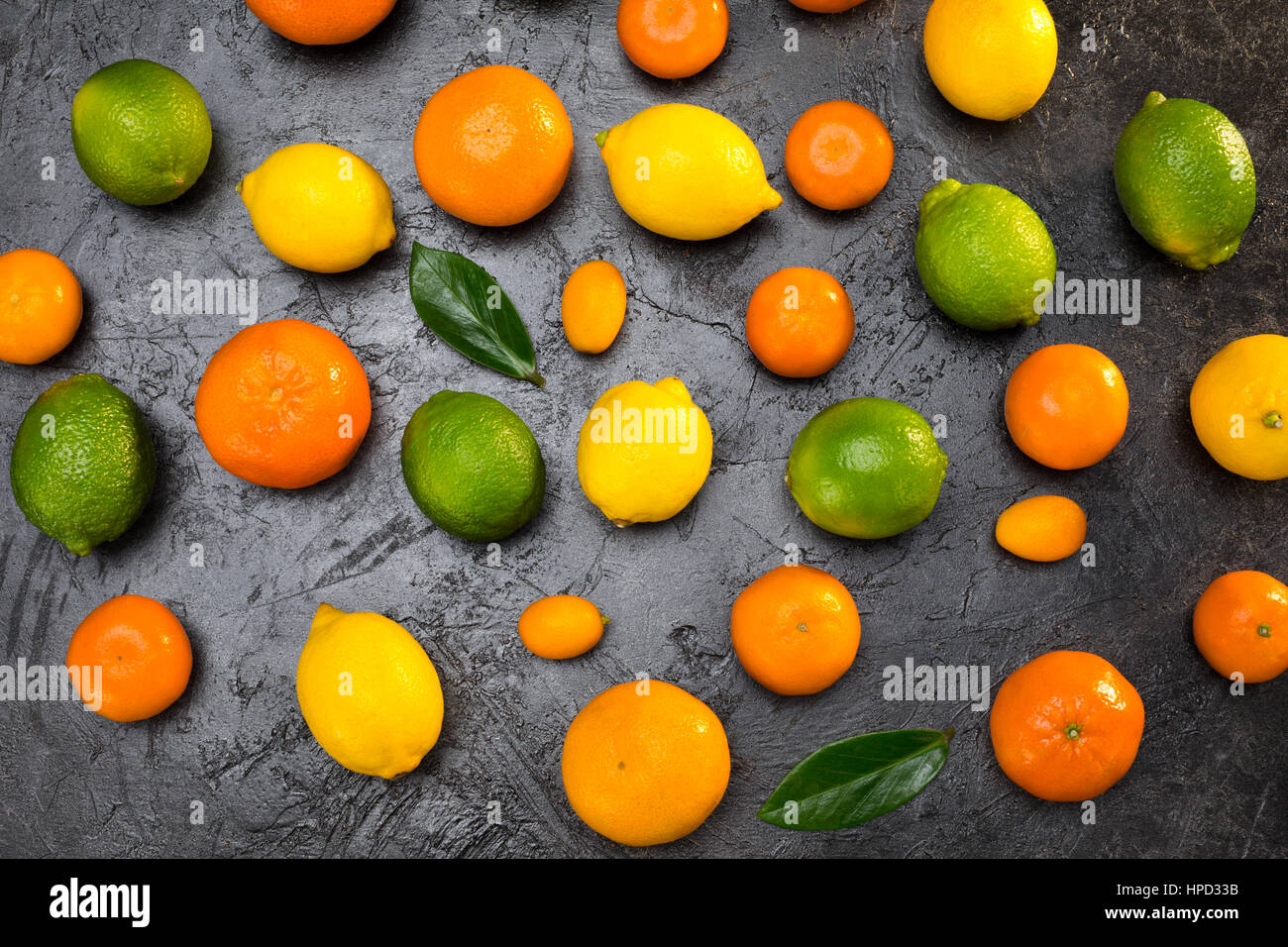 top view of fresh whole citrus fruits and leaves on black Stock Photo ...