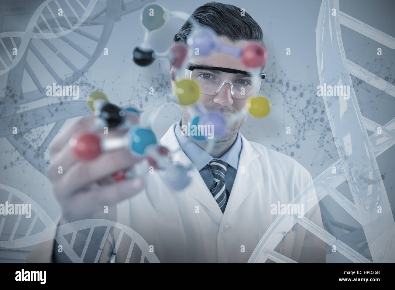 Portrait of scientist holding molecule structure against device screen ...