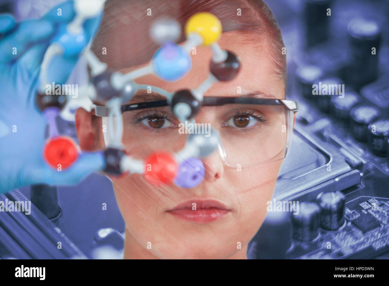 Portrait of female scientist holding molecular model against detail ...