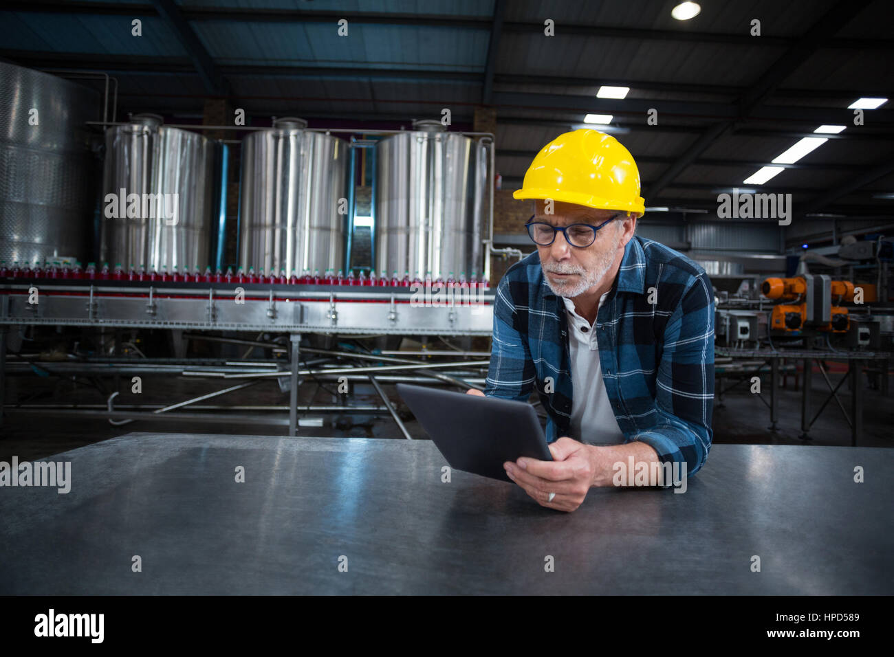 Factory worker using digital tablet at drinks production factory Stock ...