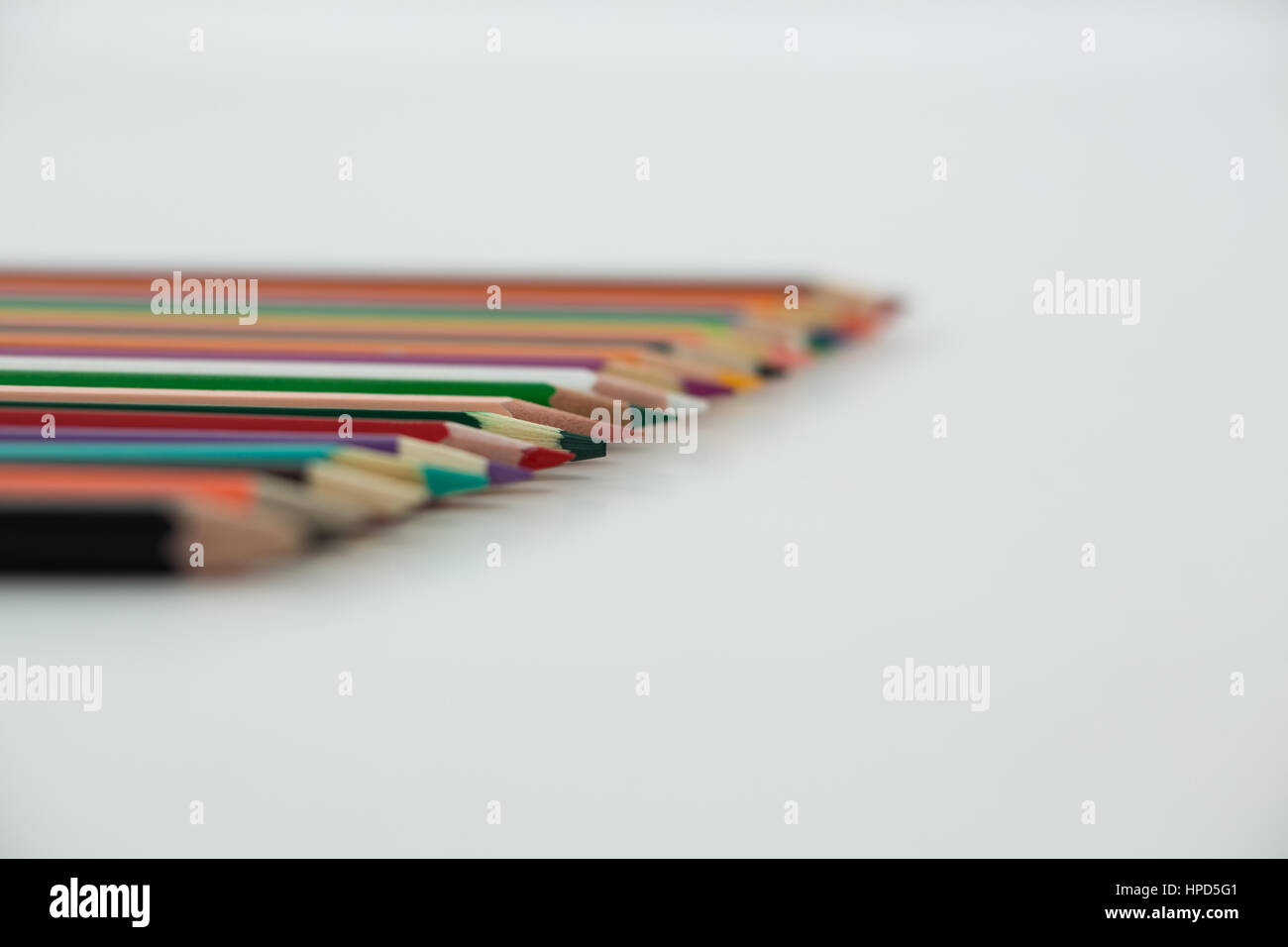 Colored pencils arranged in a row on white background Stock Photo - Alamy