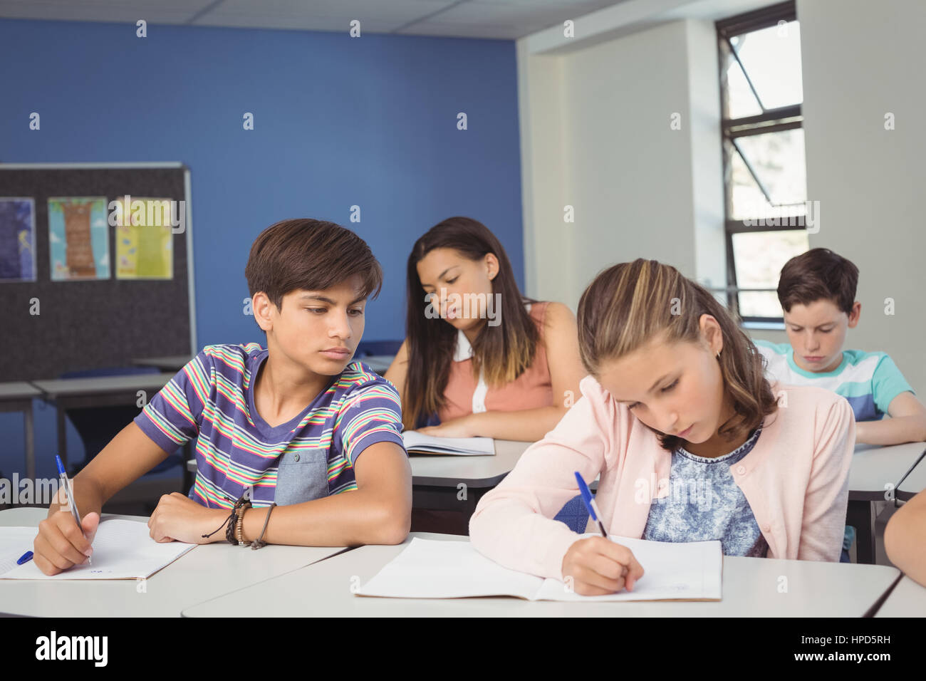Attentive school kids doing homework in classroom at school Stock Photo ...