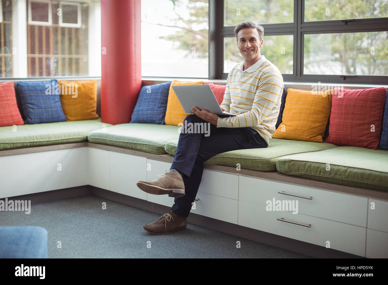 Portrait of school teacher using laptop in library at school Stock ...