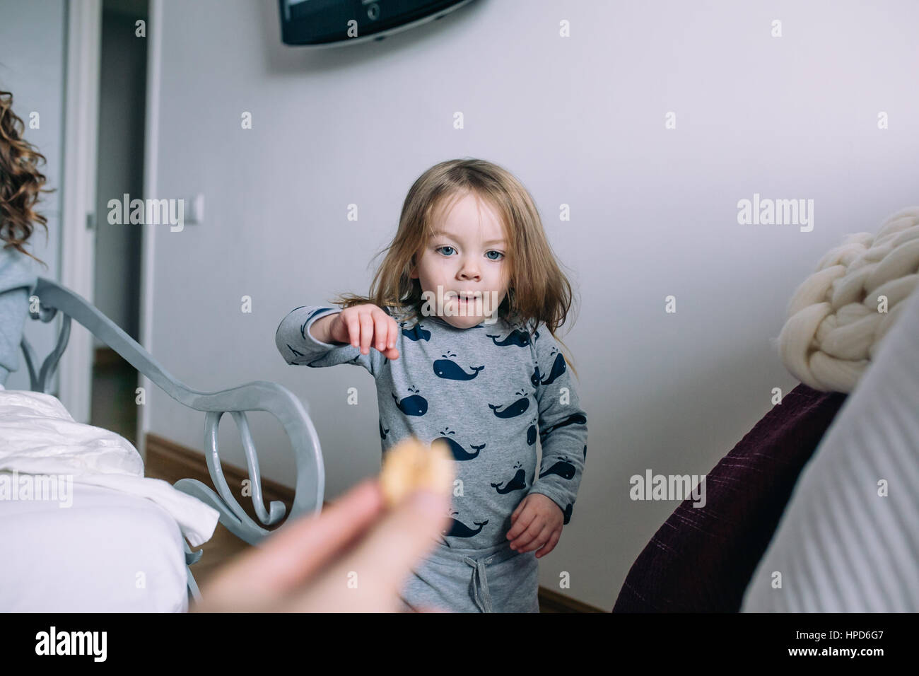 little girl in the bedroom takes something out of the hand Stock Photo ...
