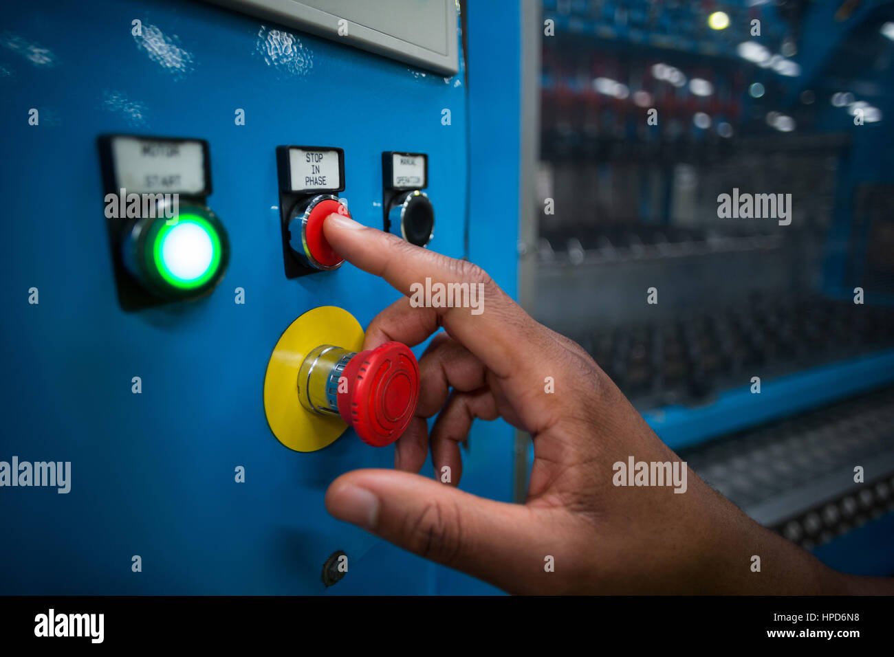 Hands of factory worker pressing a red button on the control board in ...