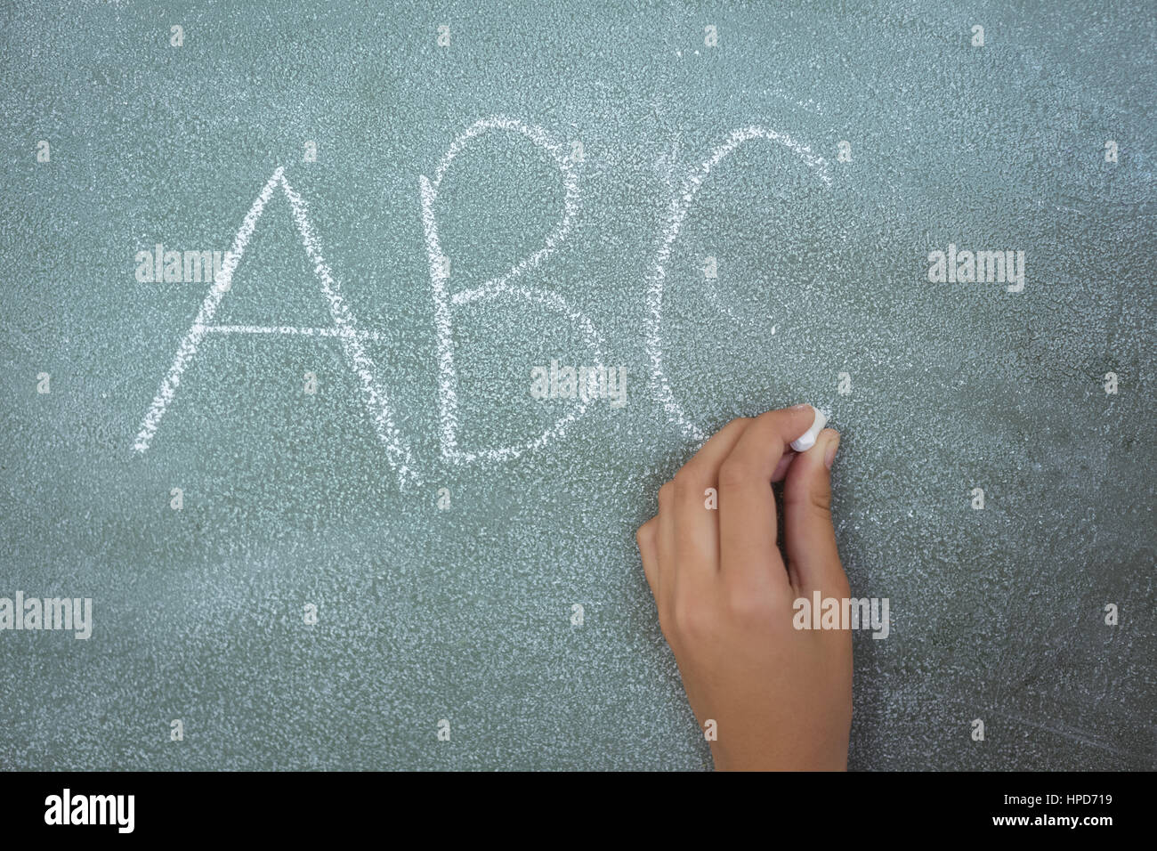 Hand of schoolgirl writing on chalkboard in classroom at school Stock ...