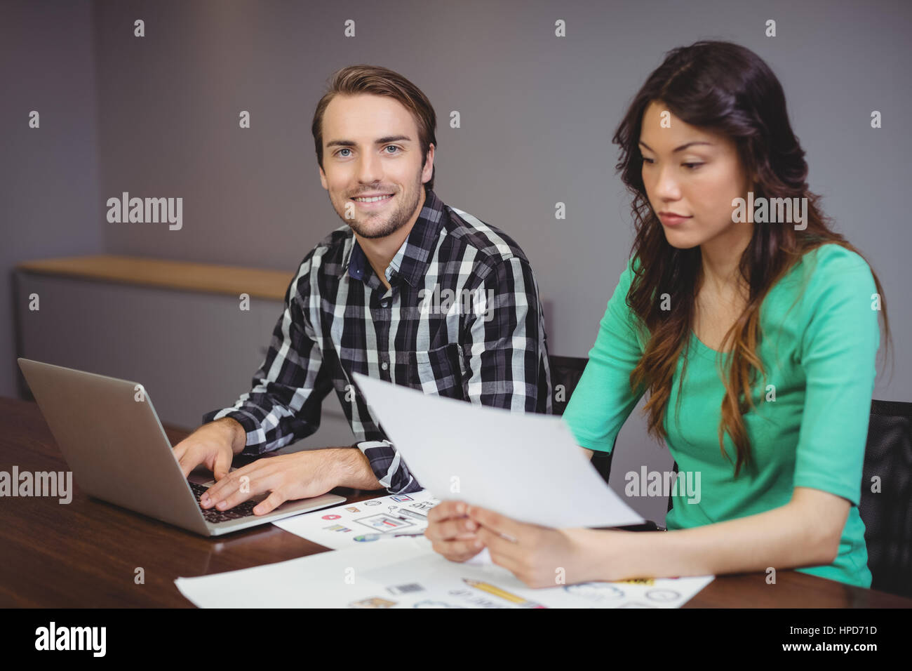 Male and graphic designers working together in conference room at ...