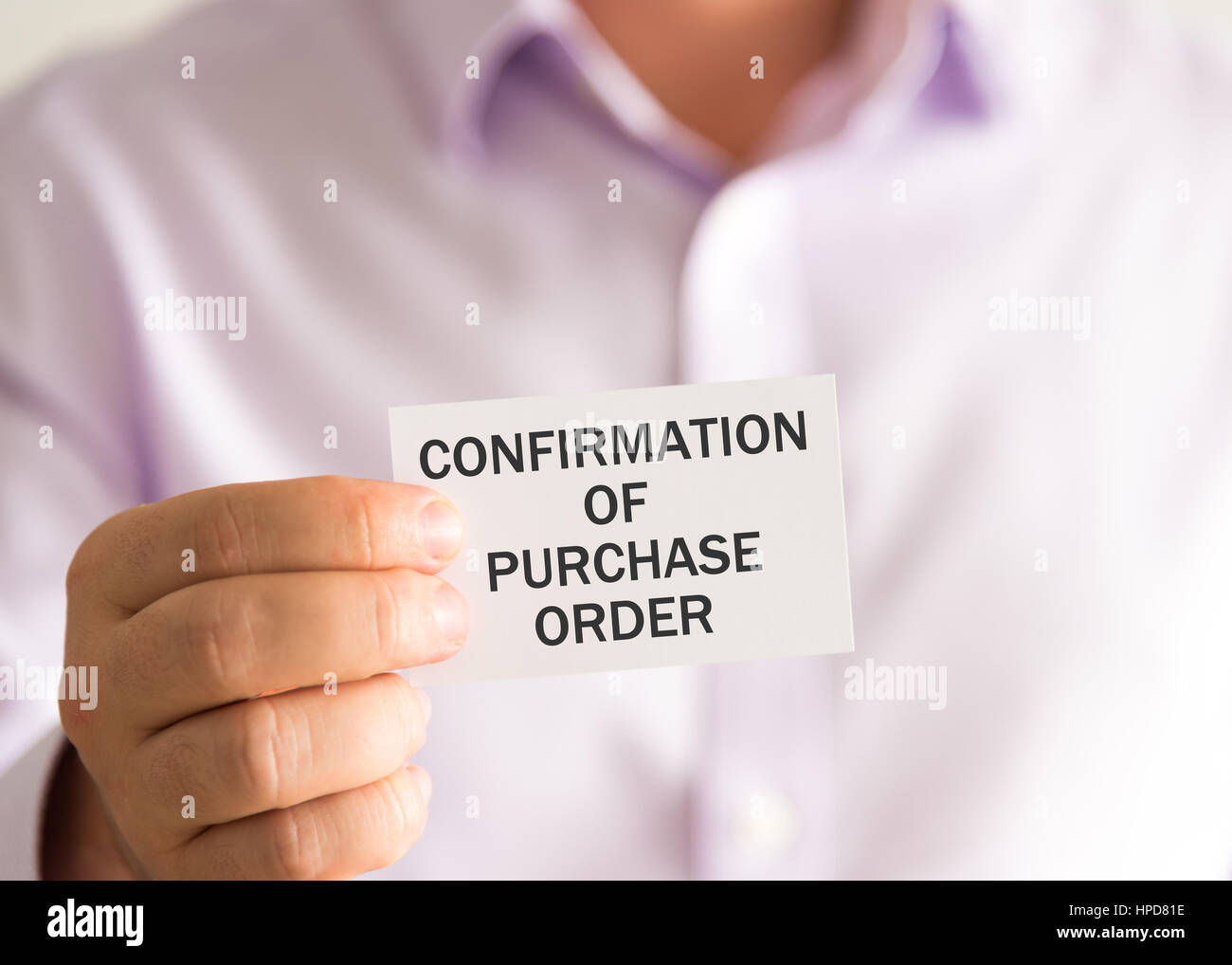 Closeup on businessman holding a card with text CONFIRMATION OF ...