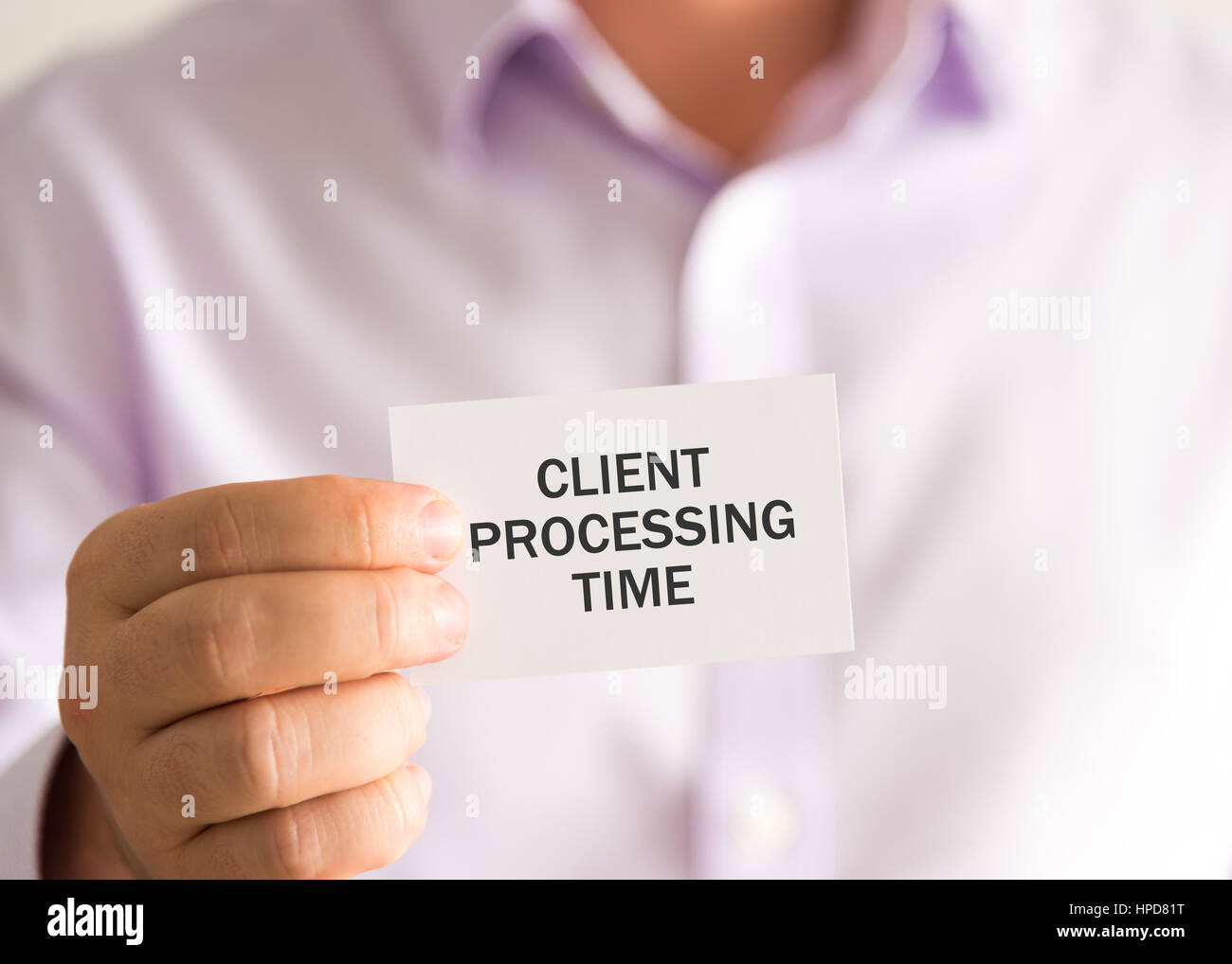 Closeup on businessman holding a card with text CLIENT PROCESSING TIME ...