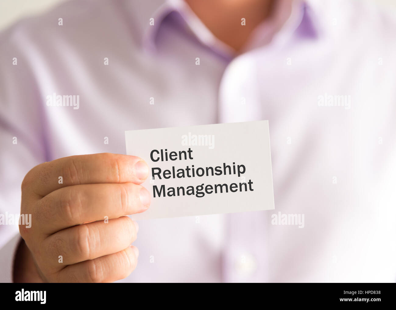 Closeup on businessman holding a card with text CRM Client Relationship ...
