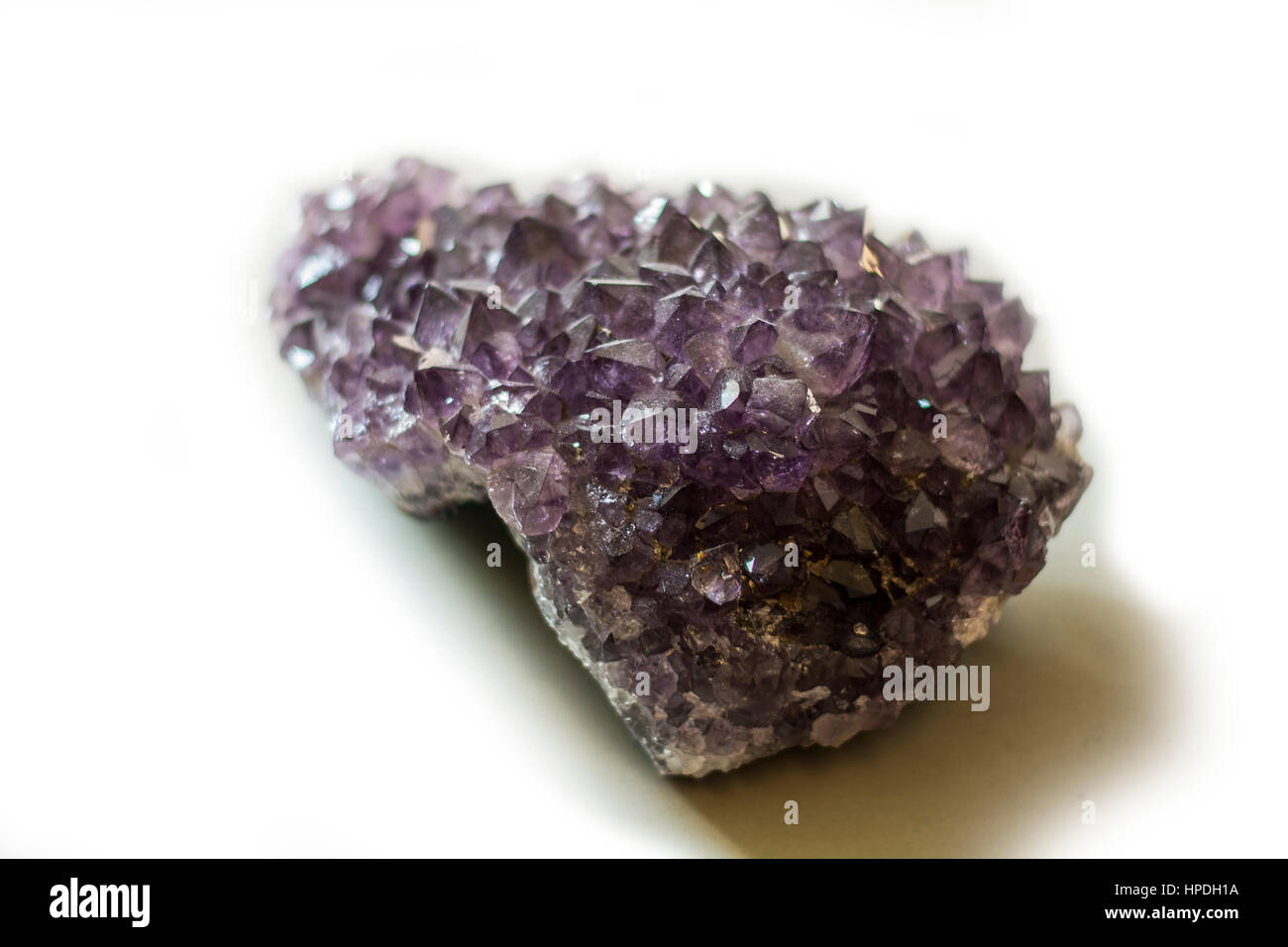 An amethyst stone placed on the white background. Horizontal studio ...