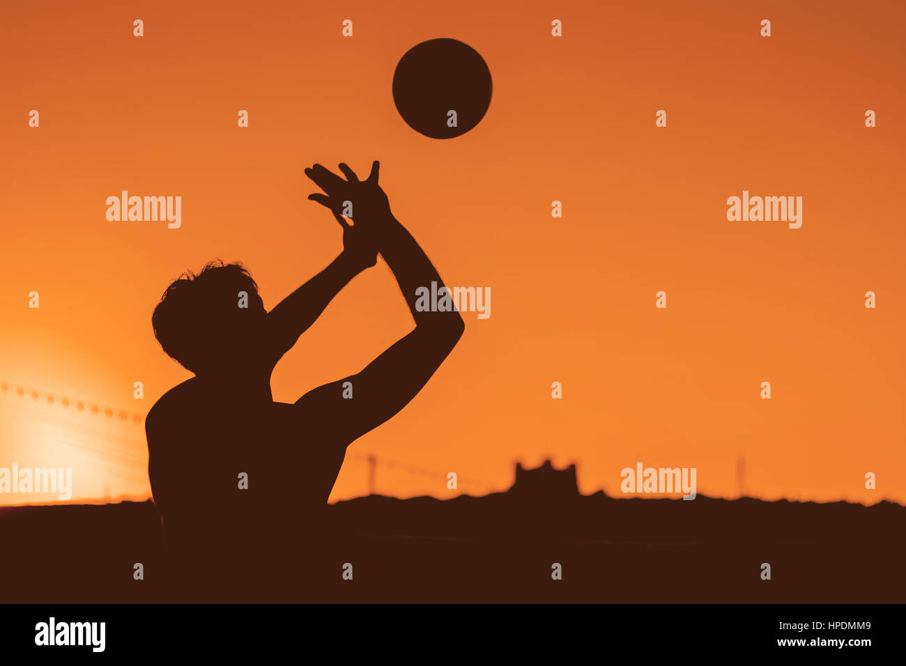 Playing volleyball in sunset. Shadow style orange photo Stock Photo - Alamy