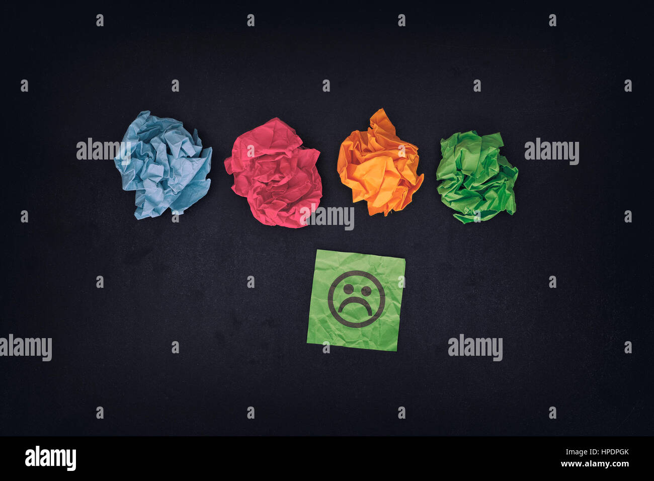 Colorful paper balls and sad face on a green paper note. Idea Concept ...