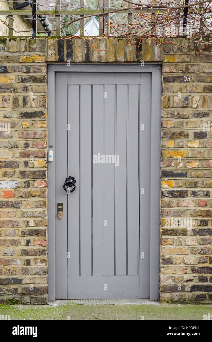 Stylish entrance to the estate surrounded by a brick wall, gray wooden ...