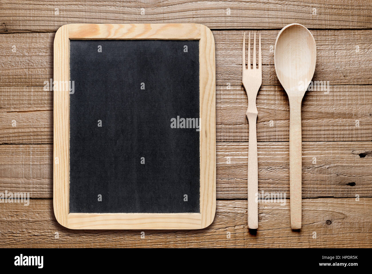 Blank blackboard, wooden fork and knife on table Stock Photo - Alamy