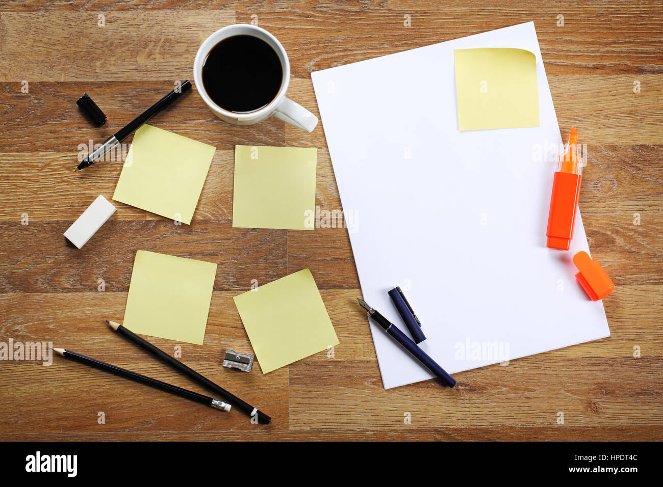 Blank sheet of paper, yellow sticky notes and pen on bright wooden ...