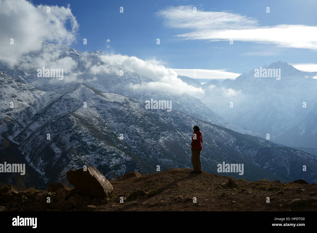 Hiker looking at Atlas mountains above town Imlil, winter, Marocco ...
