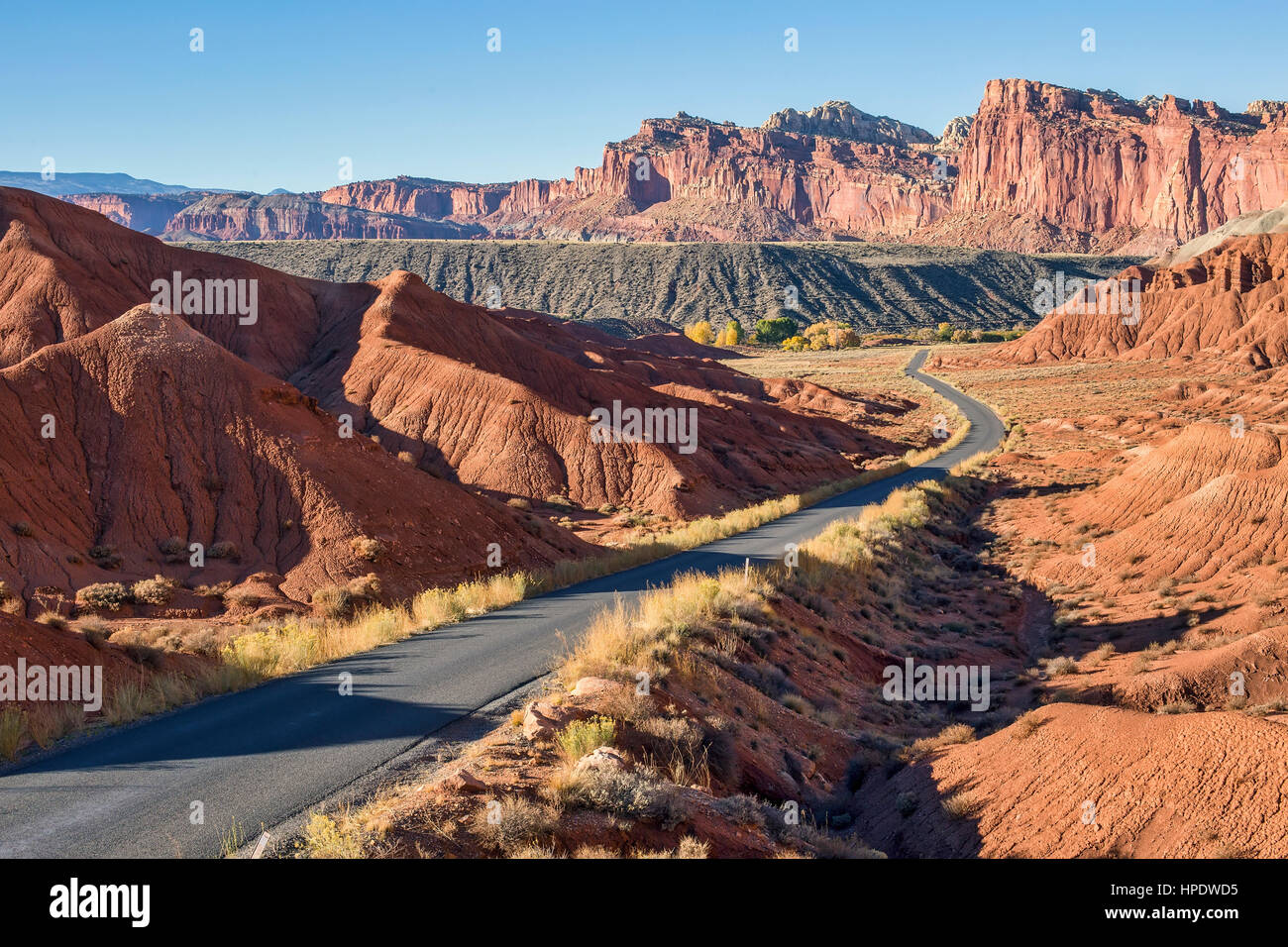 A narrow paved road winds through rocky desert mountains. Taken at ...