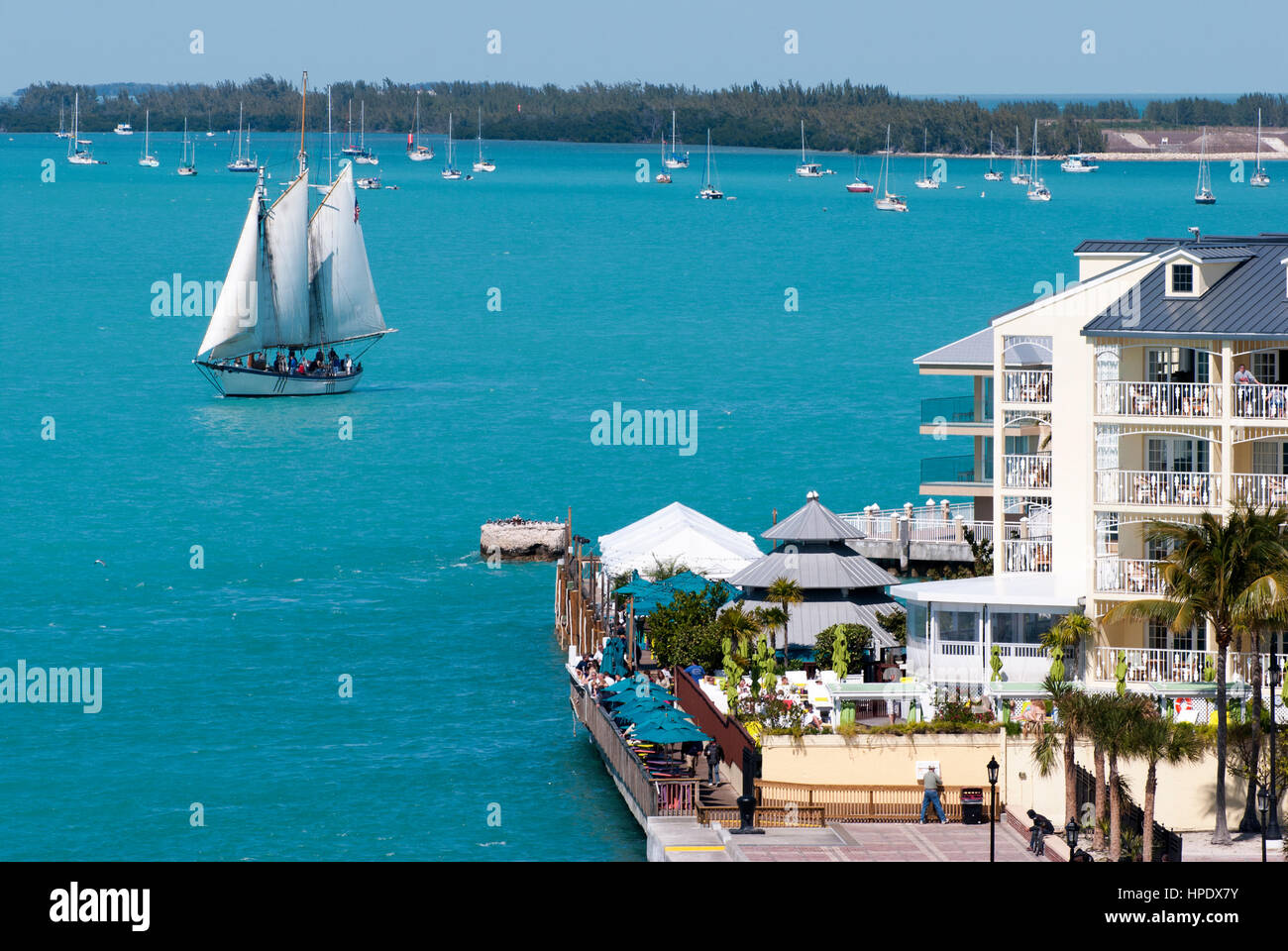 The boat with tourists passing by the resort building in Key West town ...