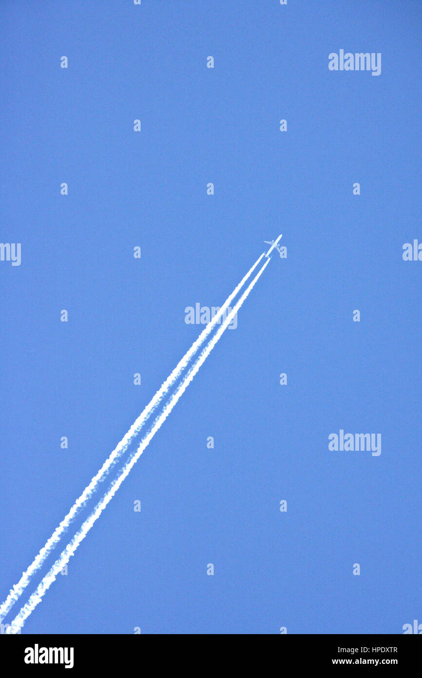 Vapour trails from a jet. A jet soaring into a cloudless , Summer sky ...