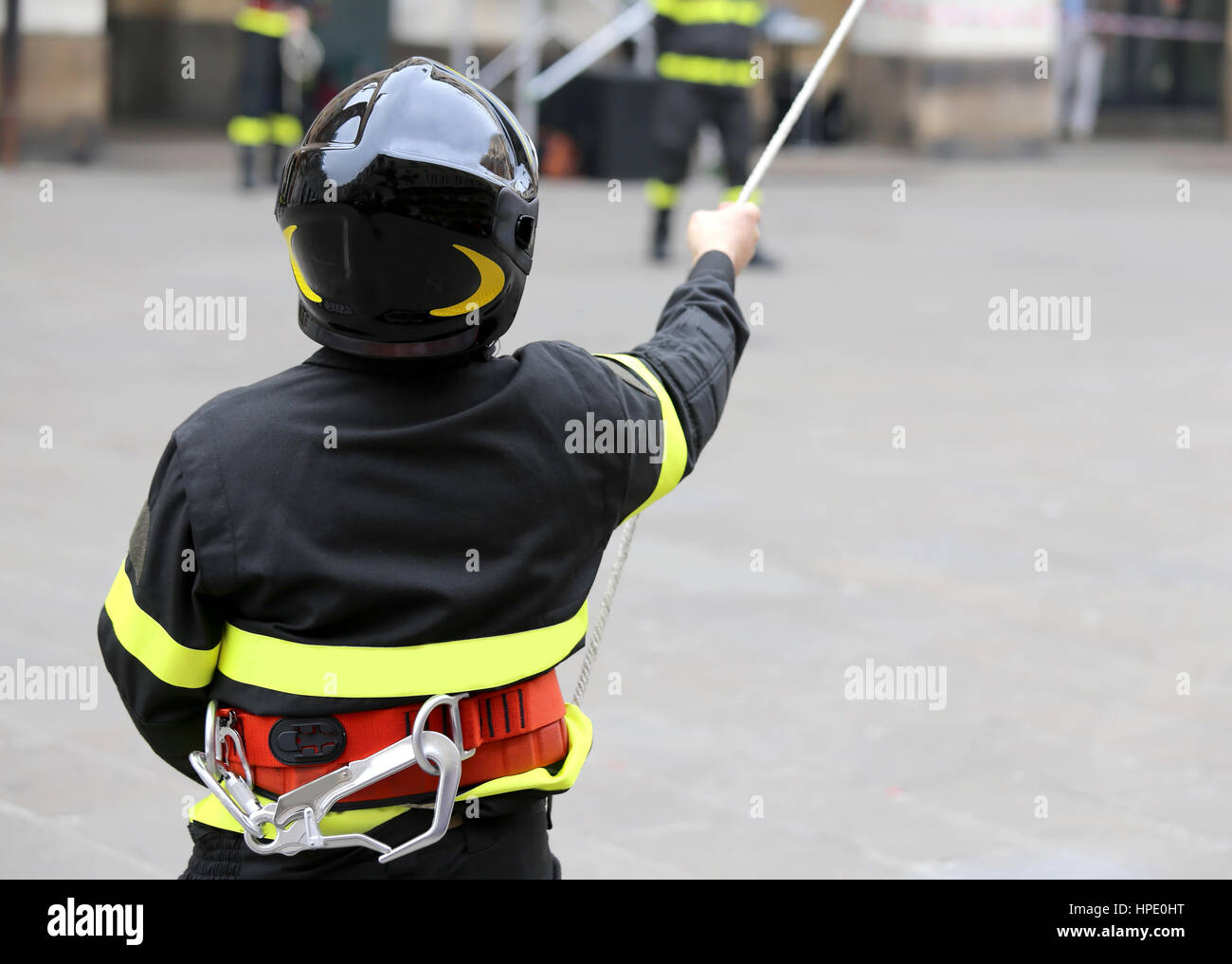 firefighter with hardhat during rescue operations with a long rope ...
