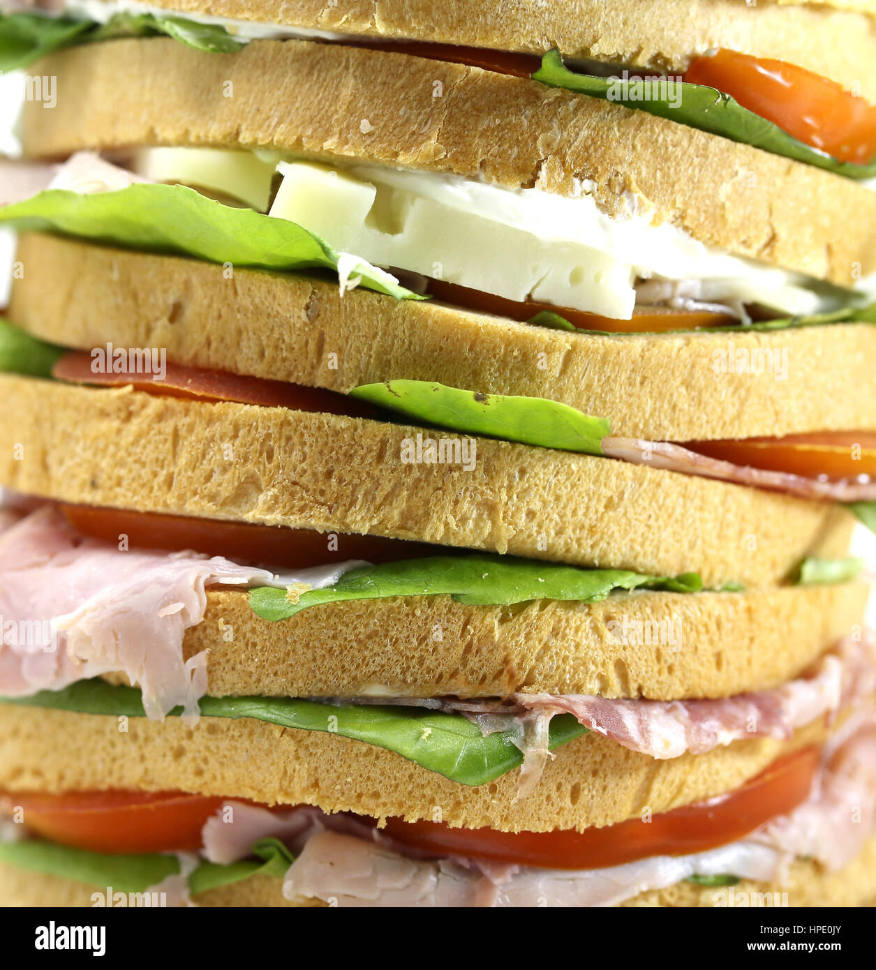 giant sandwich stuffed with many layers of bread with lettuce tomato ...