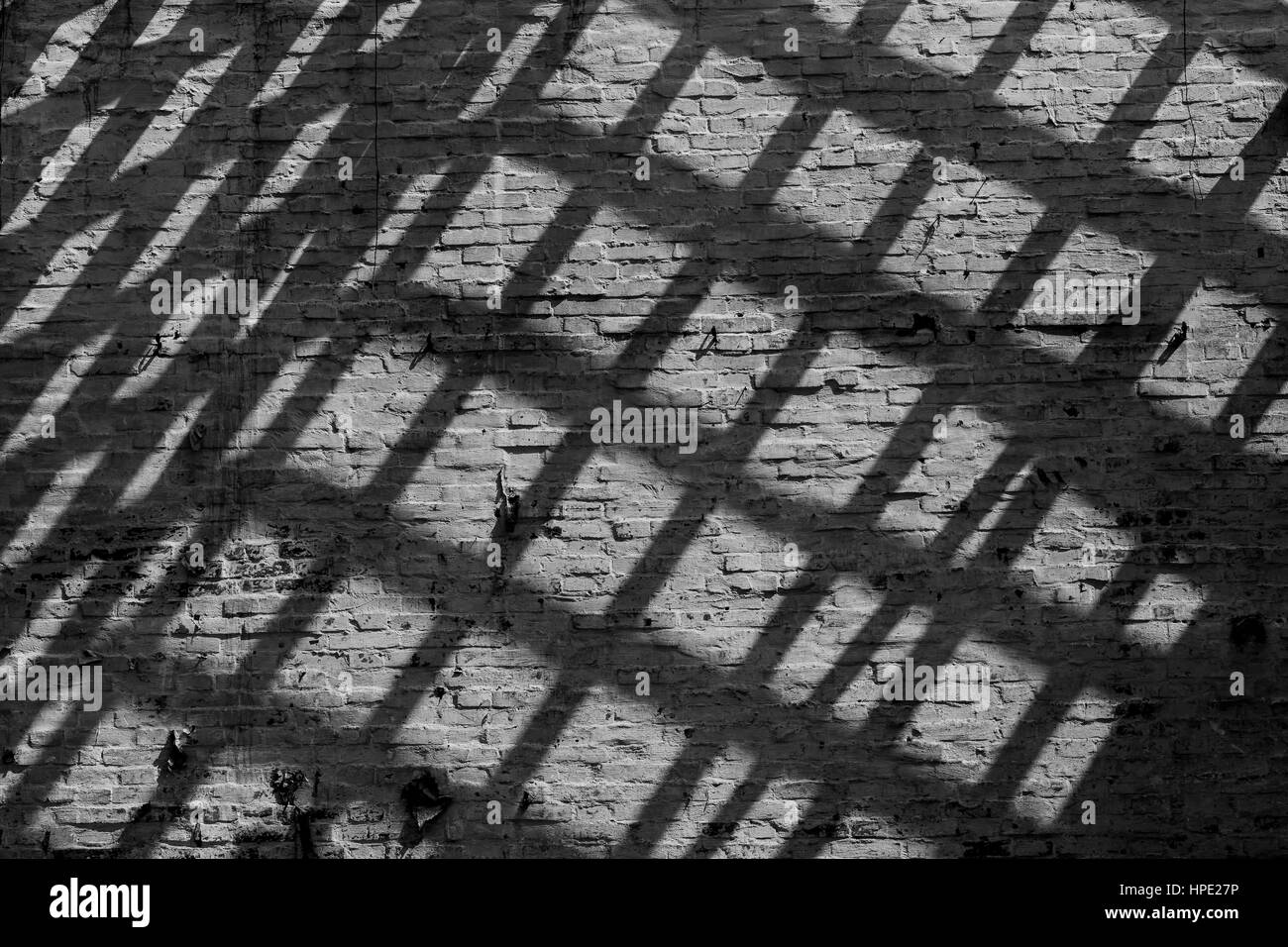 Brick wall with dark geometrical shadows Stock Photo - Alamy