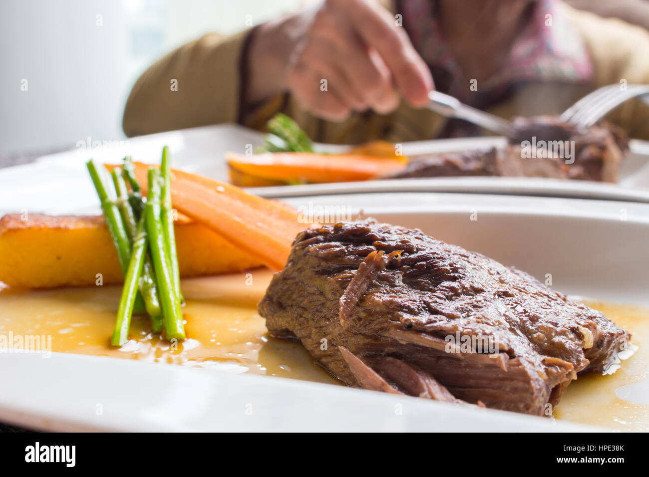 Delicious stew beef on a plate - soft focus Stock Photo - Alamy