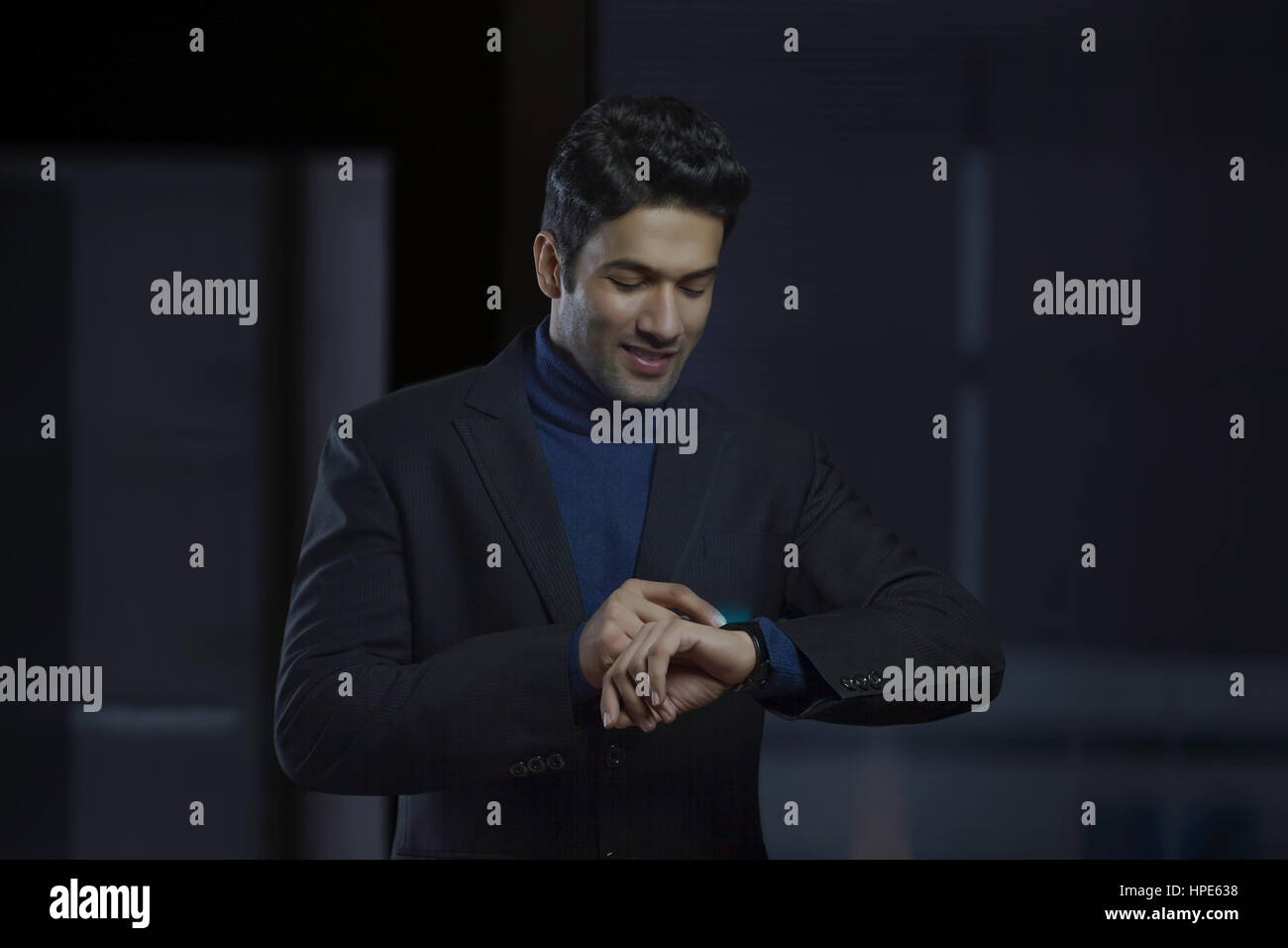 Portrait of young businessman checking the time Stock Photo - Alamy