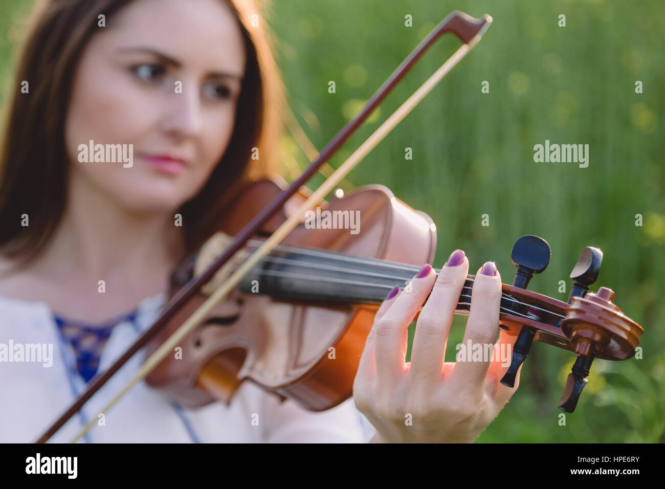 Young woman playing violin in a field at sunset Stock Photo - Alamy