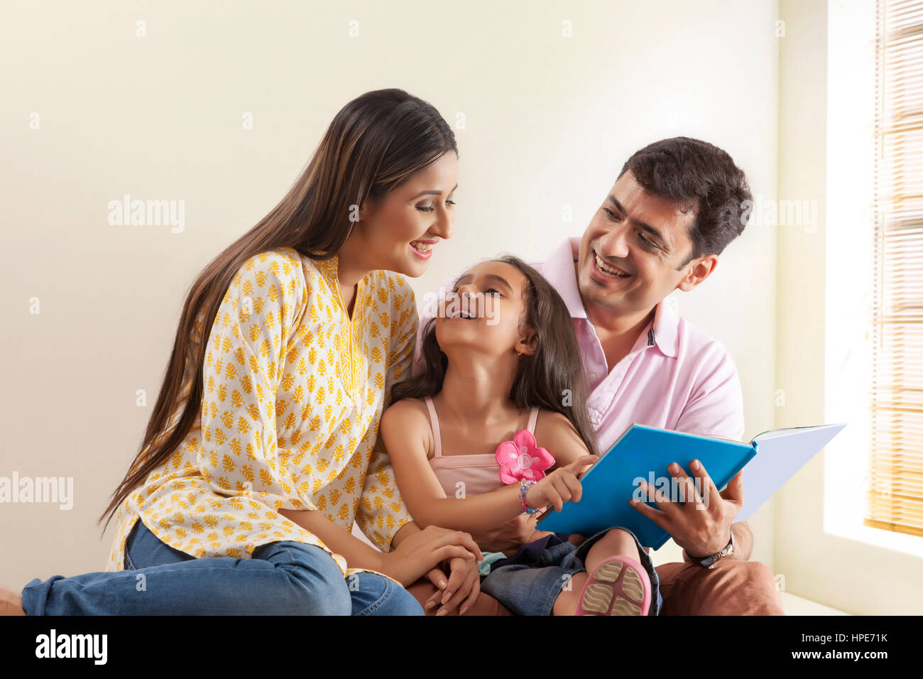 Parents looking at photo album with their daughter Stock Photo - Alamy