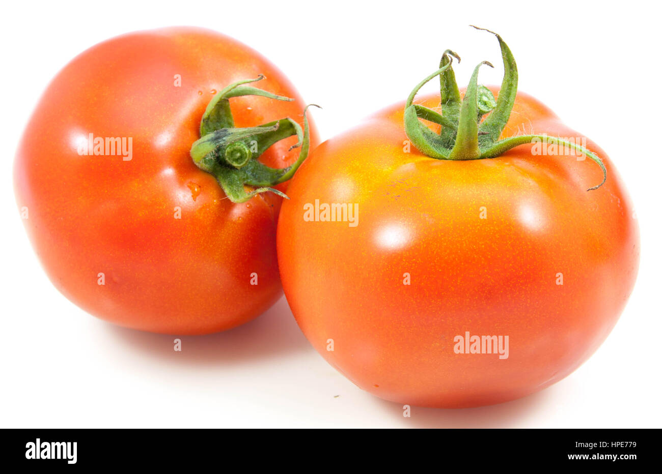 two tomato balance on white background Stock Photo - Alamy