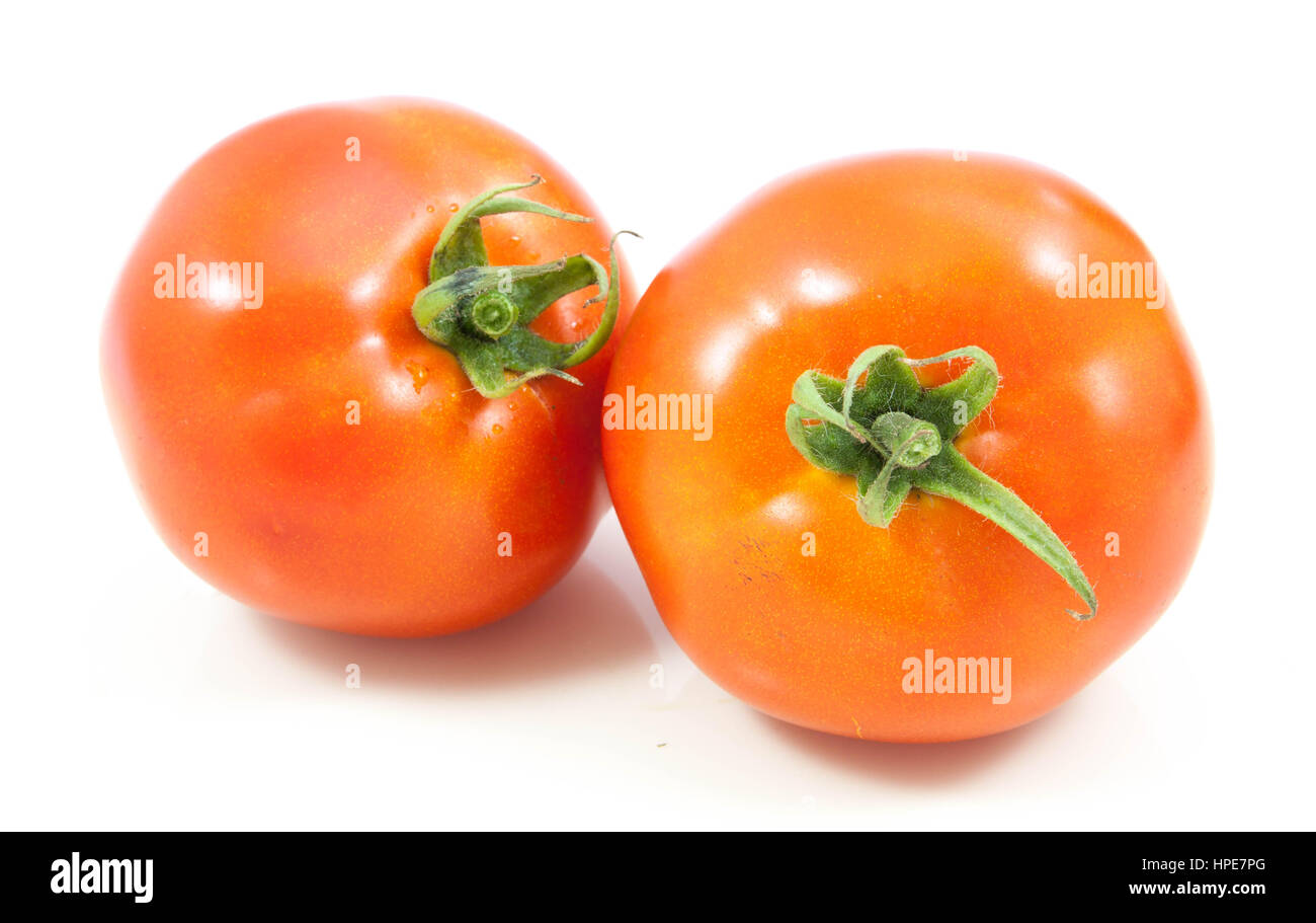 two tomato balance on white background Stock Photo - Alamy