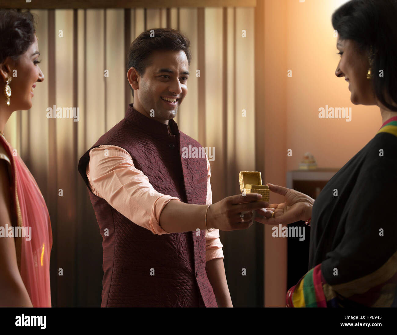 Man presenting gift to his mother Stock Photo - Alamy