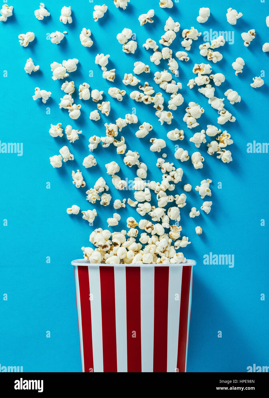 Popcorn explosion on blue background, cinema and entertainment concept ...