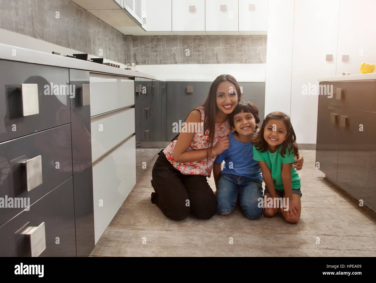 Mother and children in modern kitchen Stock Photo - Alamy