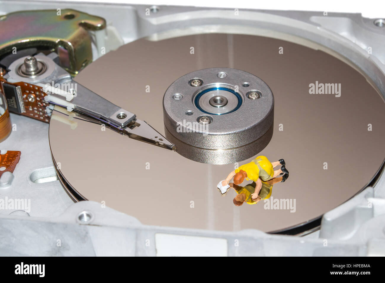 Cleaning the hard disk. A woman cleans a HDD. Figurine of a woman ...